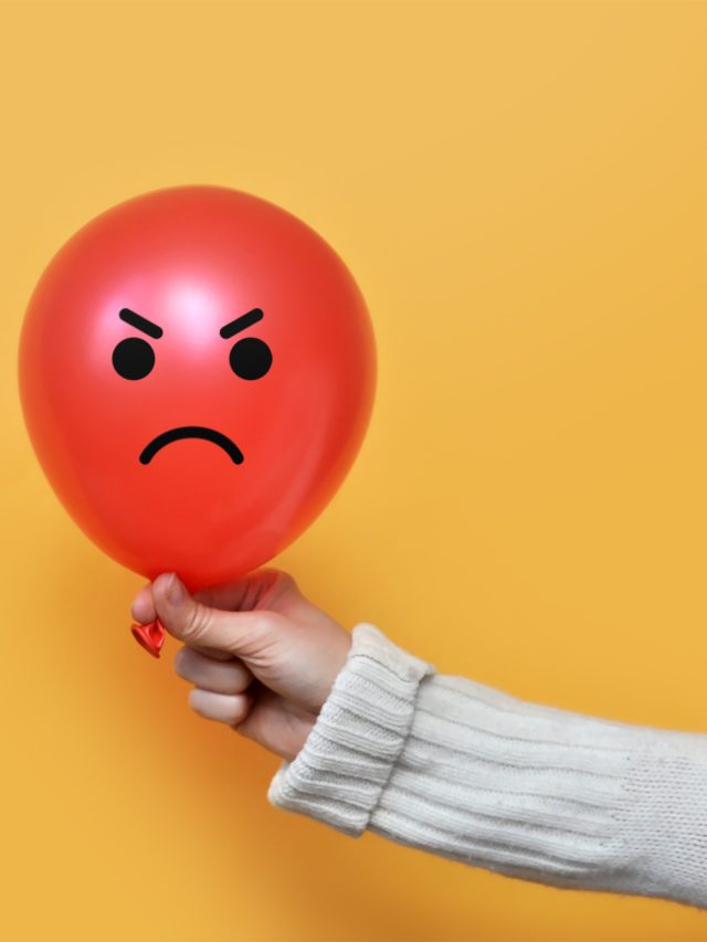 A balloon with an angry face in the hand of a man. Anger in a pe ...